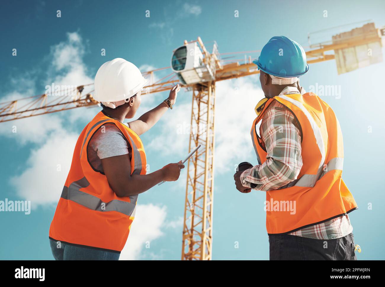 The construction experts in action. a young man and woman working with a crane at a construction ...