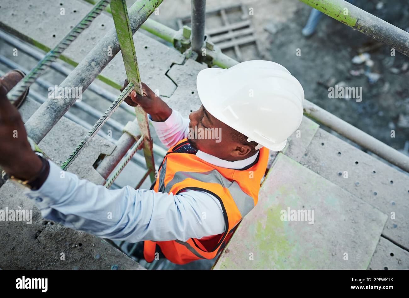 Climbing to the top of the construction industry. a young man climbing ...