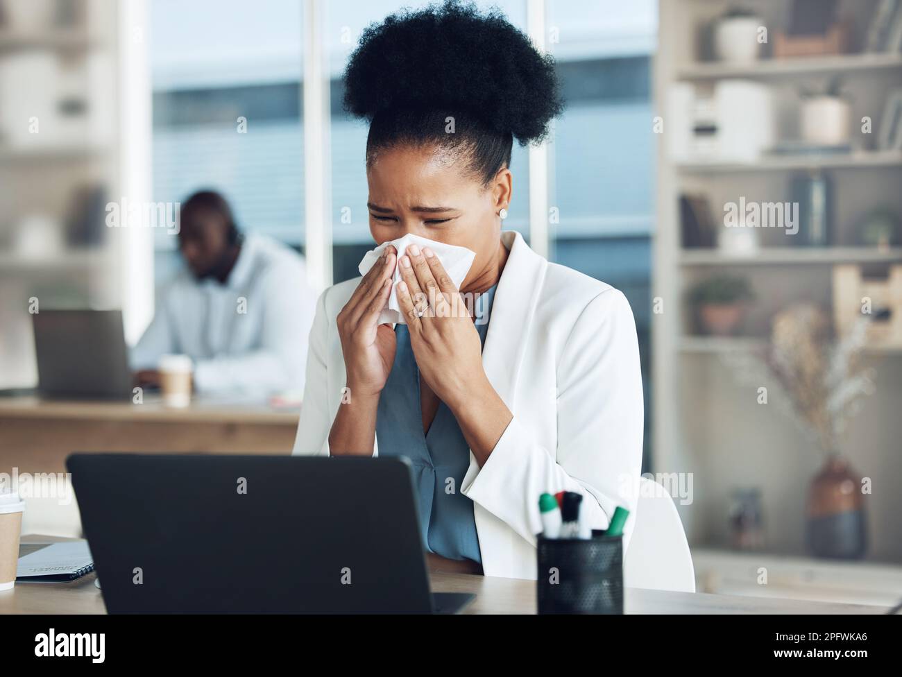 Work, healthcare and black woman at desk blowing nose with tissue paper ...