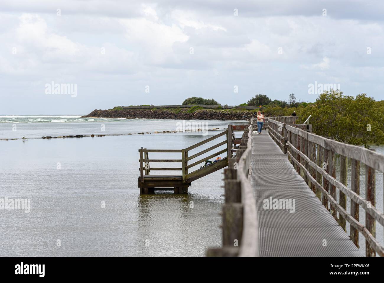 A woman fishing on the Urunga Boardwalk on a summer day Stock Photo - Alamy