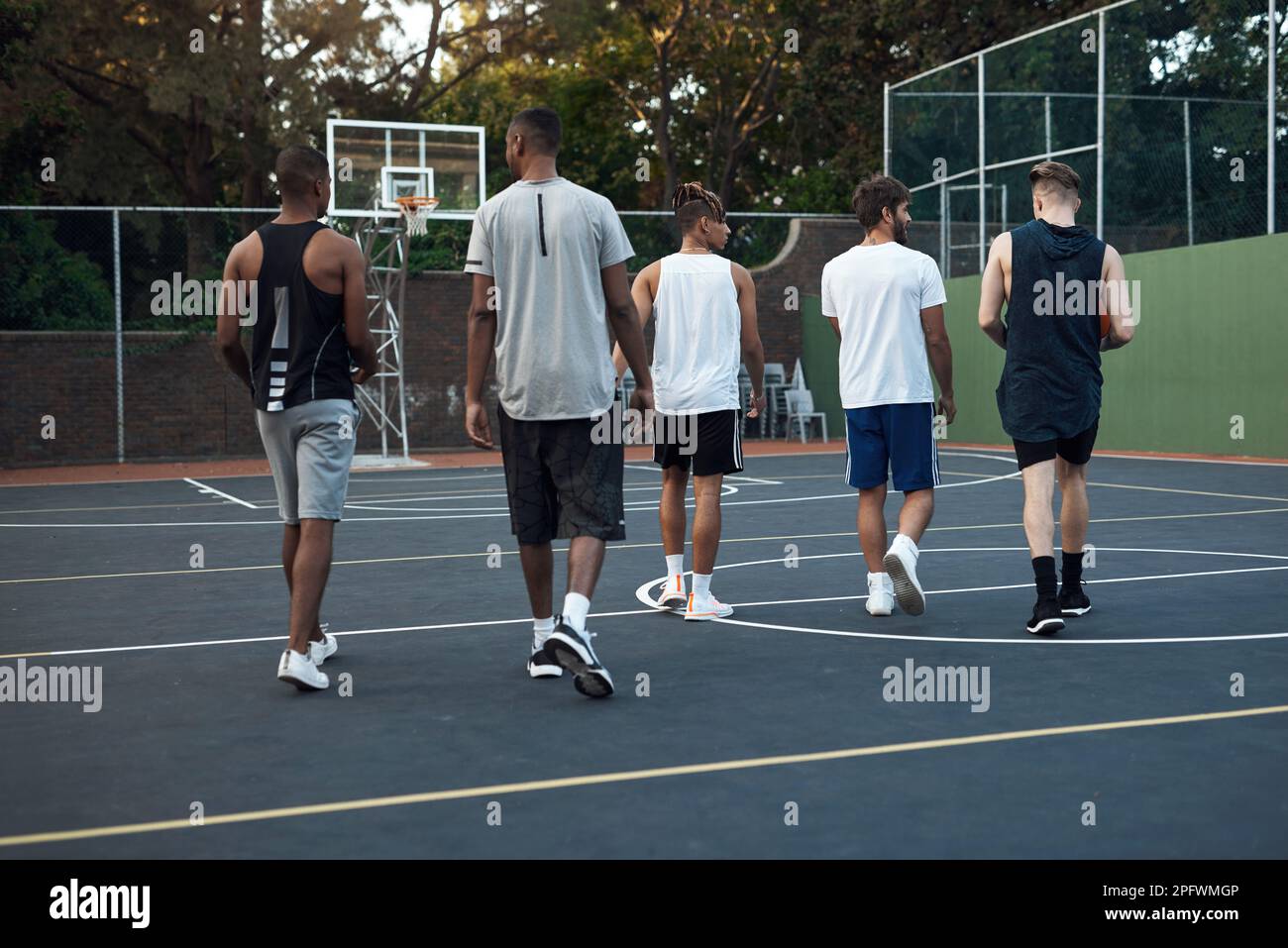 The game is about to start. Rearview shot of a group of sporty young ...
