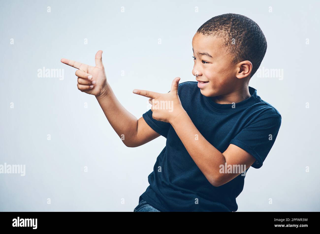I got you. Studio shot of a cute little boy pointing against a grey ...