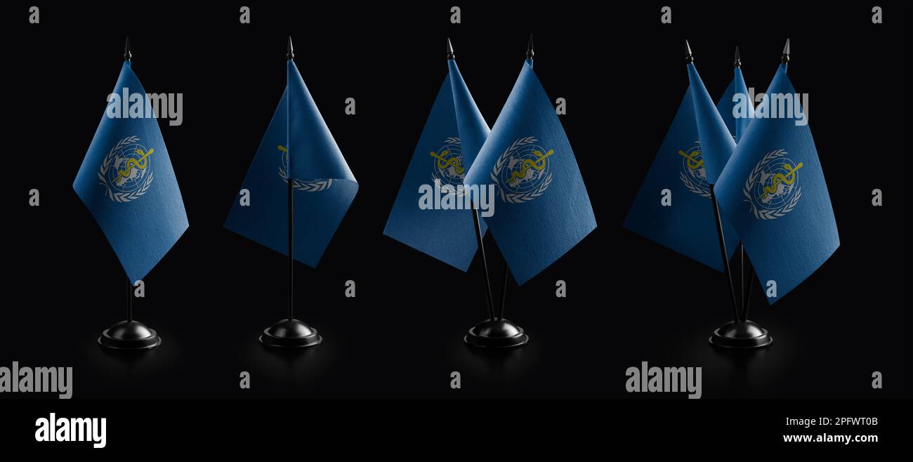 Small national flags of the World Health Organization WHO on a black ...