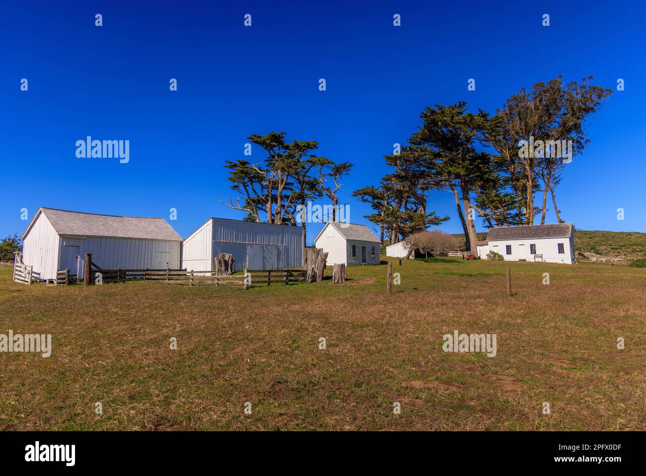 Old wooden farm buildings painted white in rural California on sunny ...