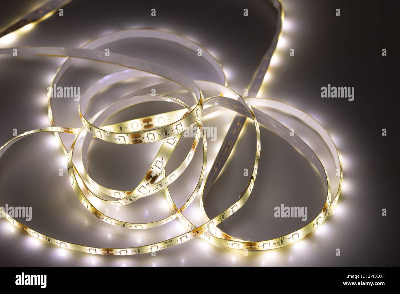 From above of untangled strip of LED light with glowing diodes on shiny ...