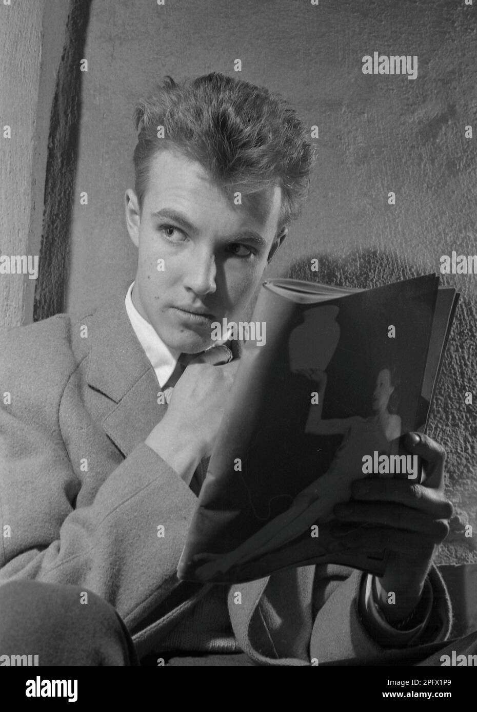 Reading A Pin Up Magazine In The 1950s A Young Man Looks Secretive When Pictured Reading A