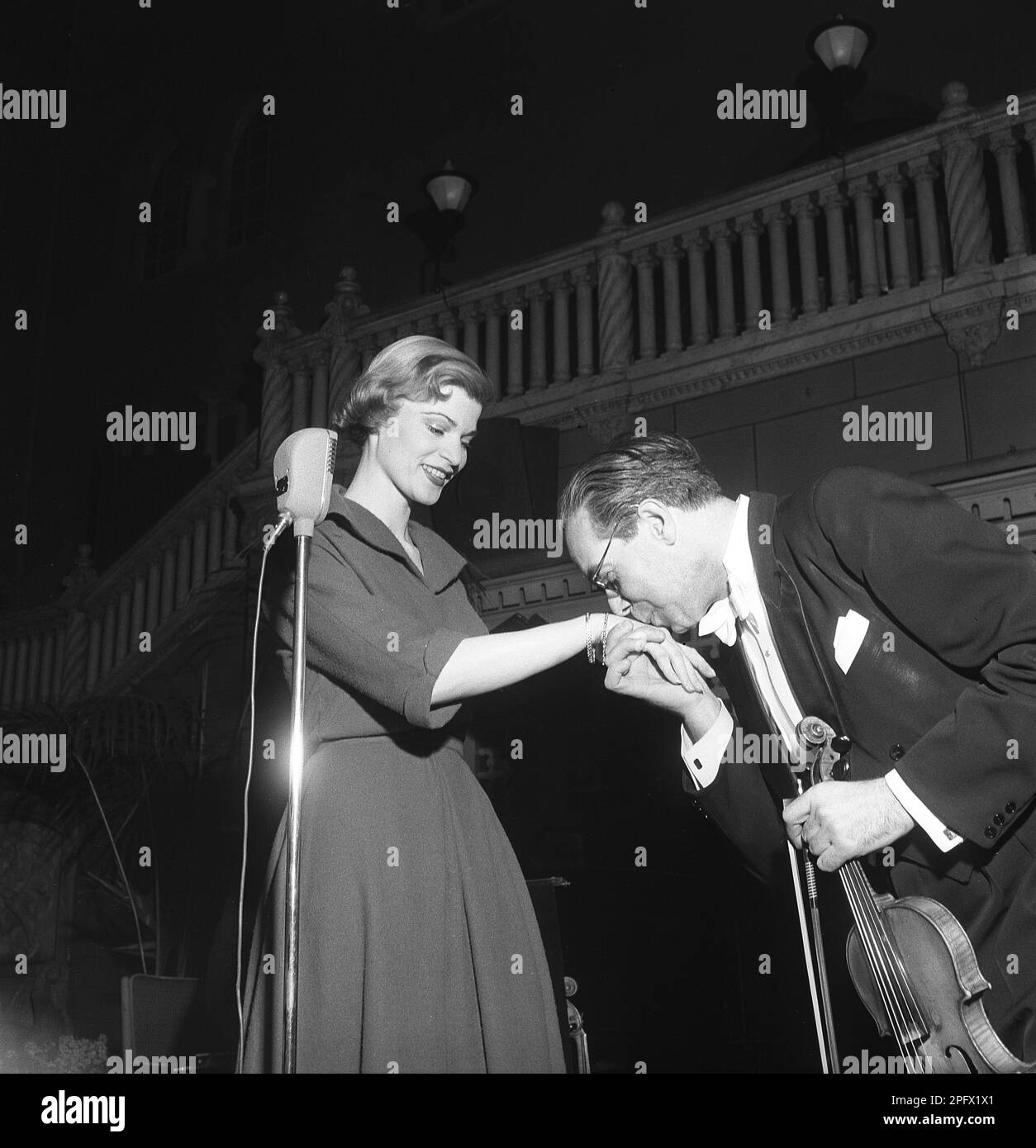 Kiss on the hand. The young woman possibly a singer holds out her hand ...