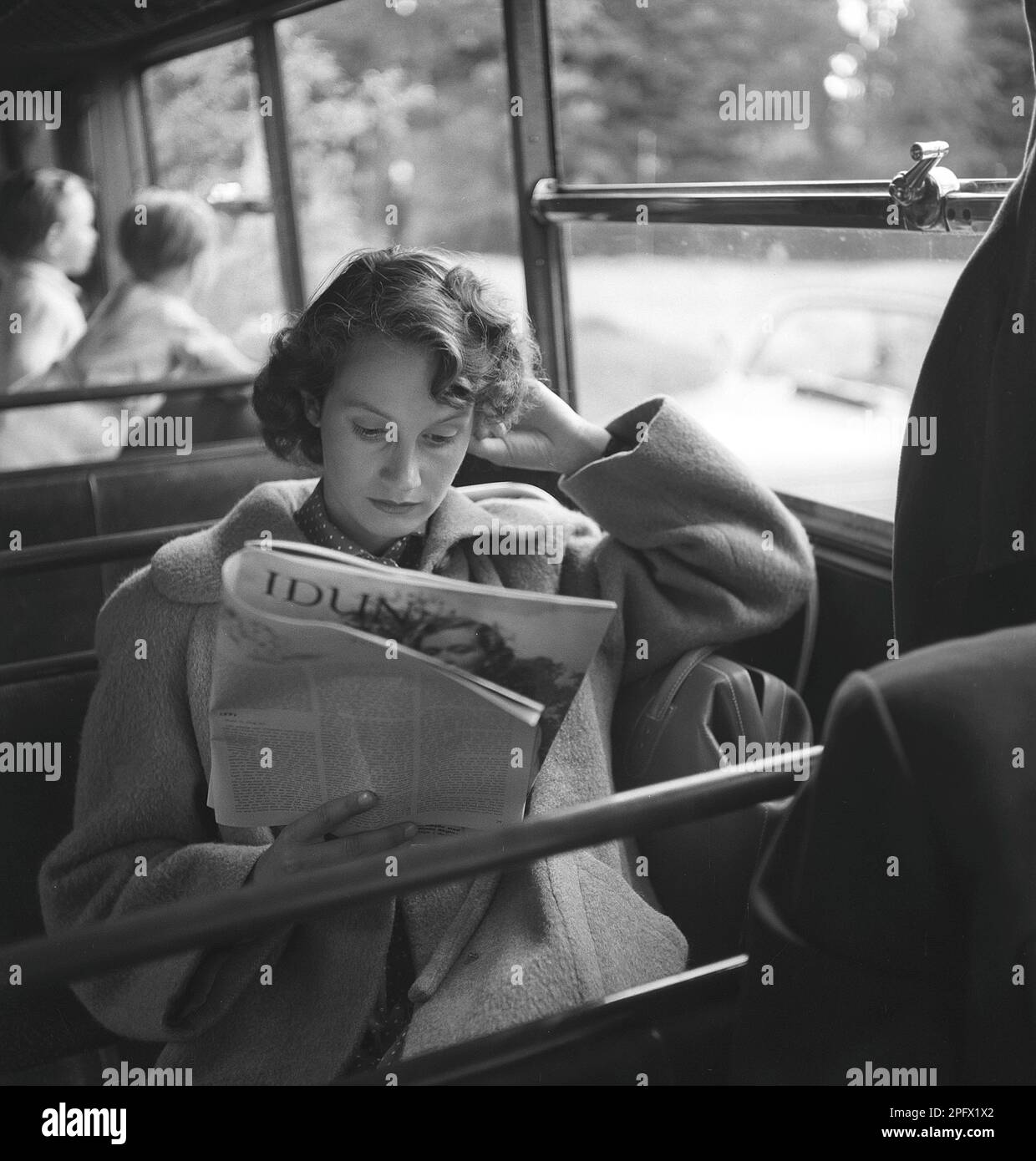 Woman in the 1950s. A young woman on a bus ride spends her time reading ...