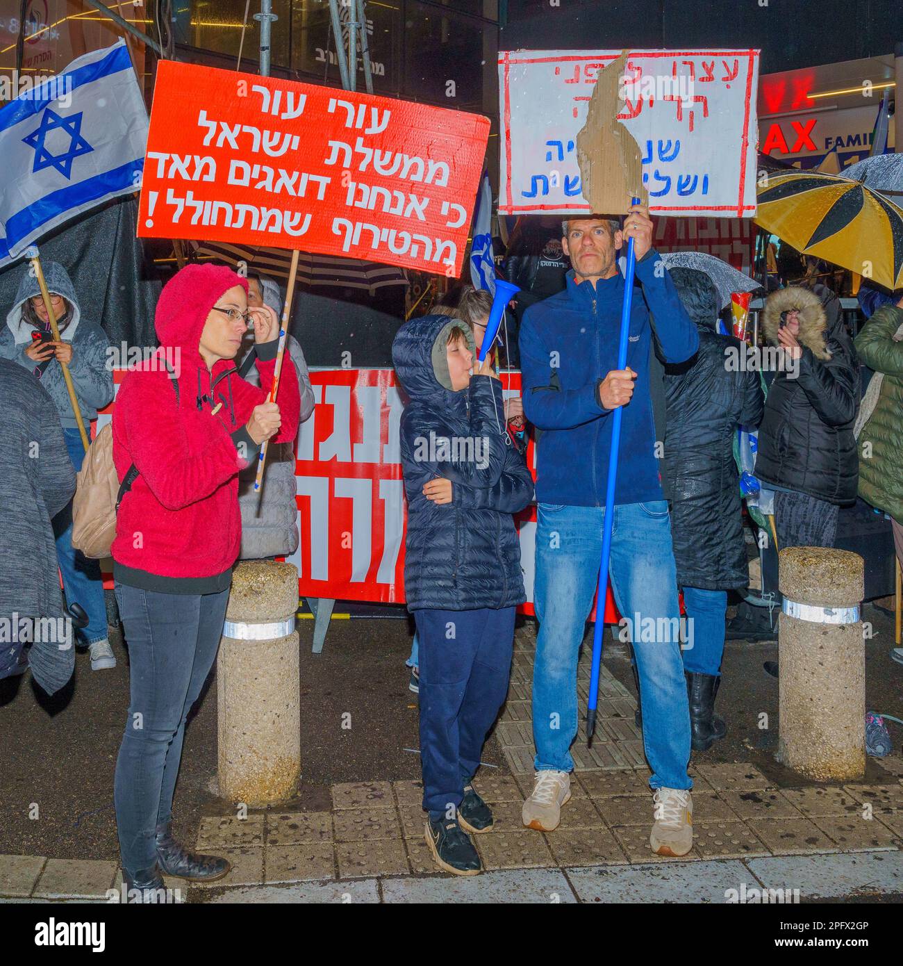 Haifa, Israel - March 18, 2023: Protesters with various signs and flags ...