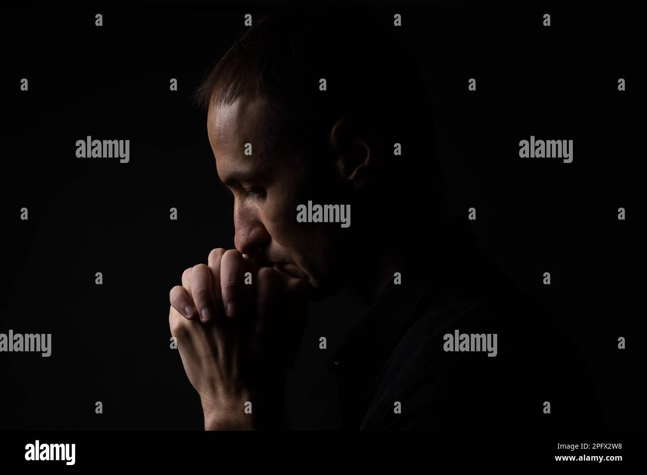 Portrait of a handsome man praying over gray background Stock Photo - Alamy
