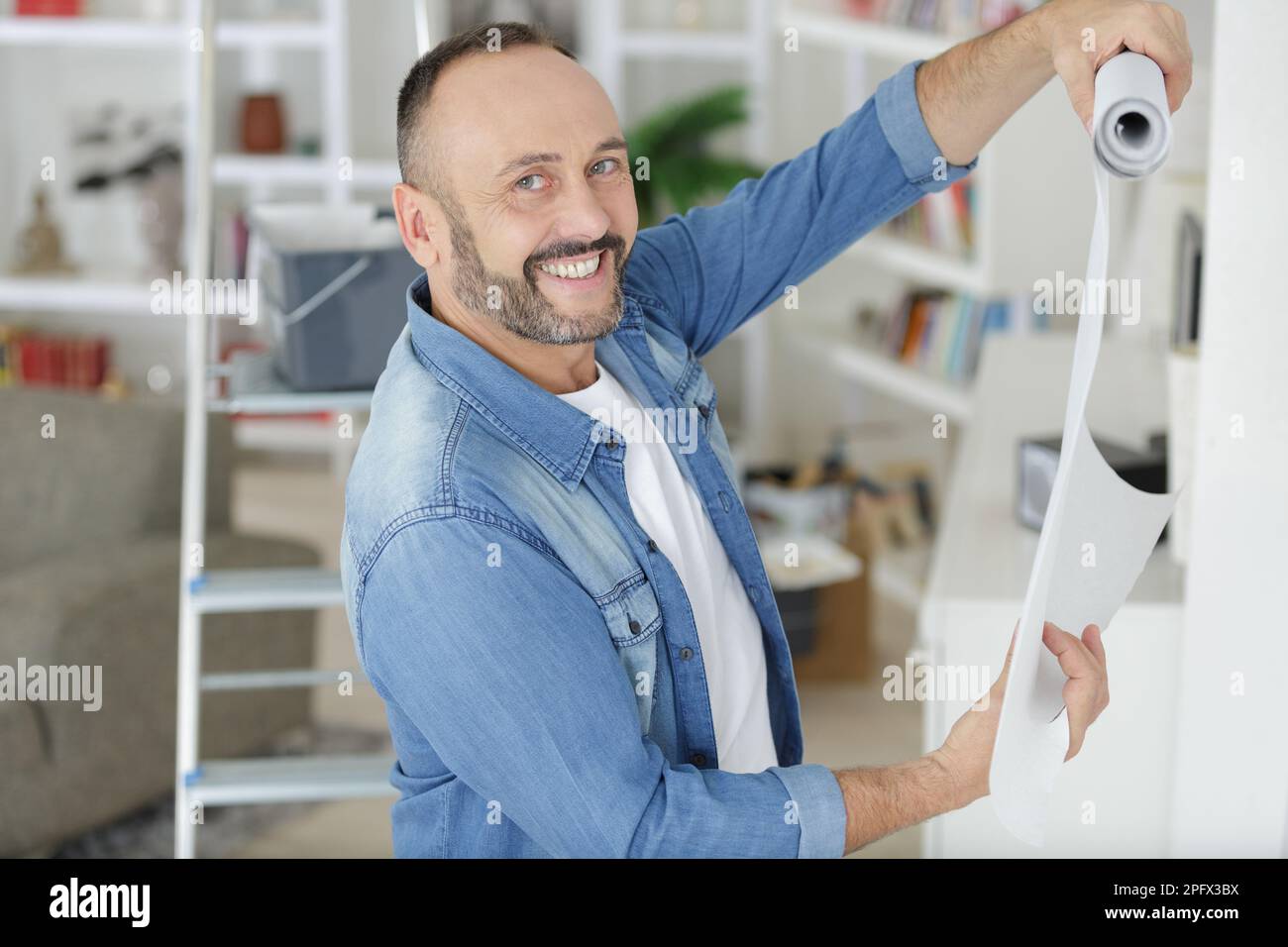 man working on wallpaper during refurbishment Stock Photo - Alamy