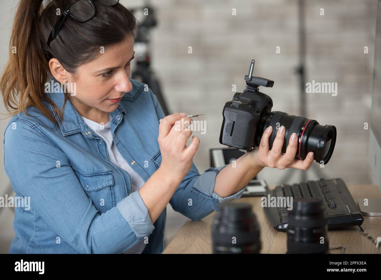 female photographer cleaning dslr fisheye camera lens Stock Photo - Alamy