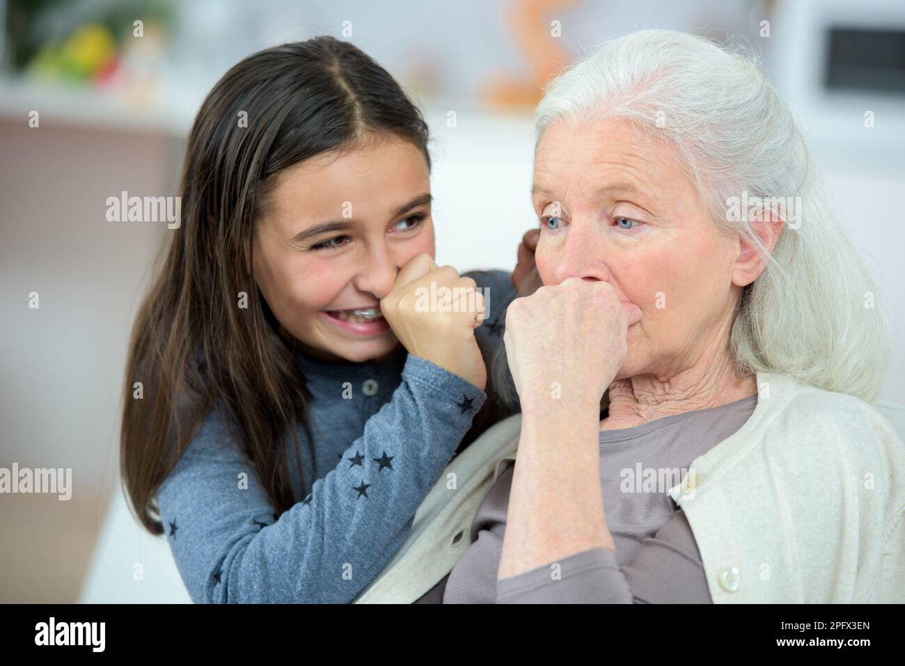 grandaughter laughing grandmother looking concerned Stock Photo - Alamy