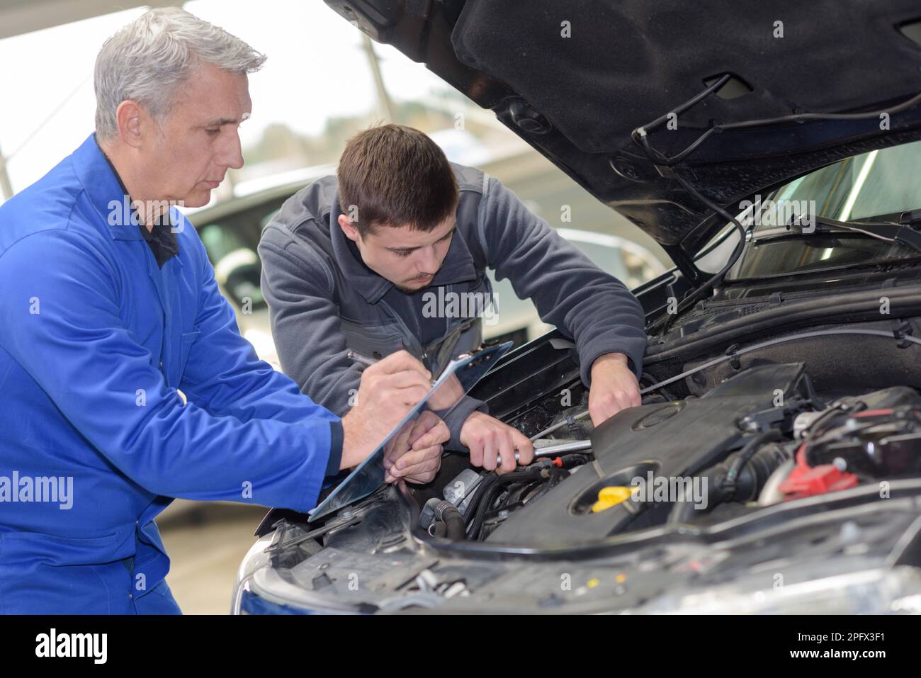student with instructor repairing a car during apprenticeship Stock ...