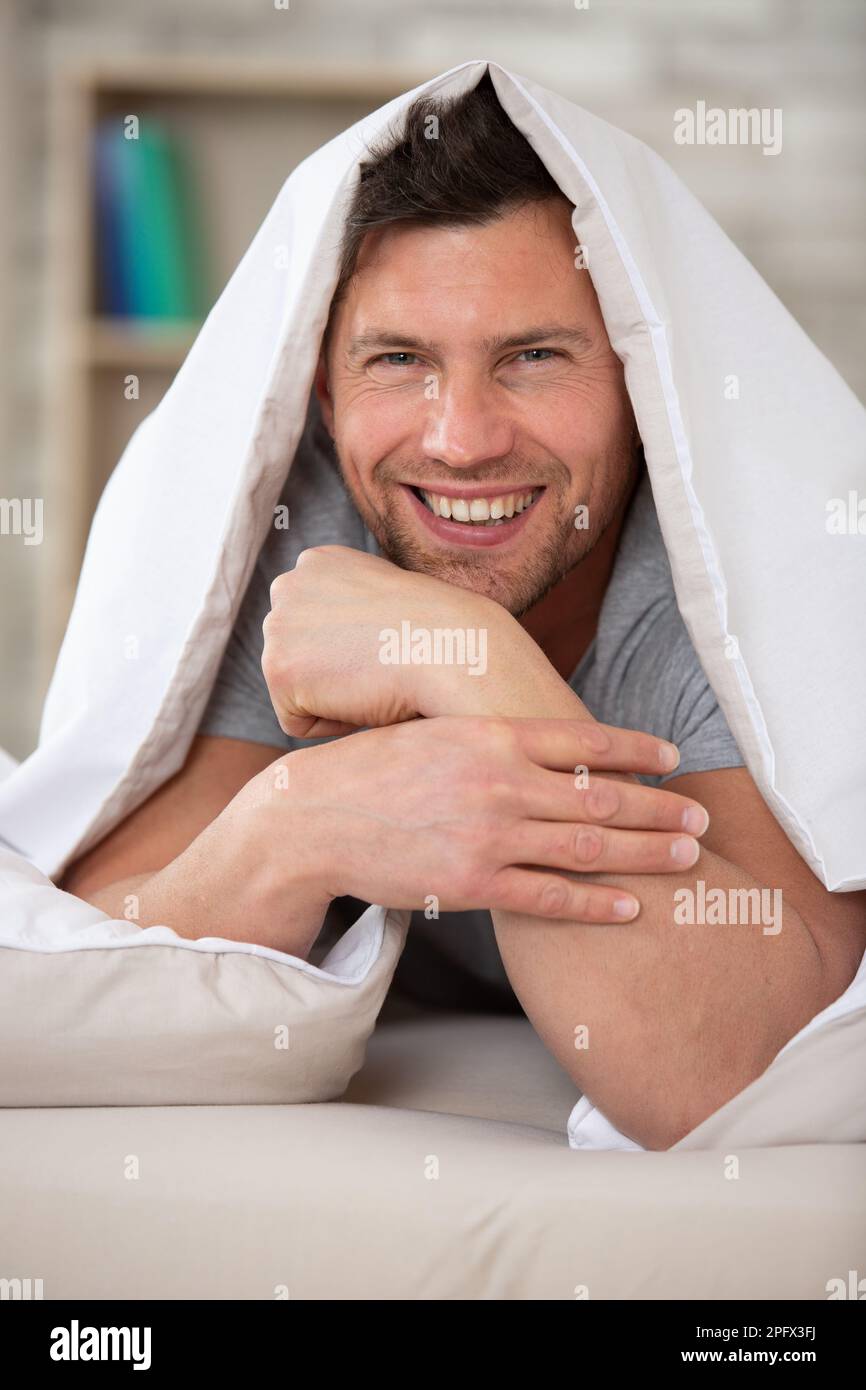 happy man hiding in bed under the blanket at home Stock Photo - Alamy