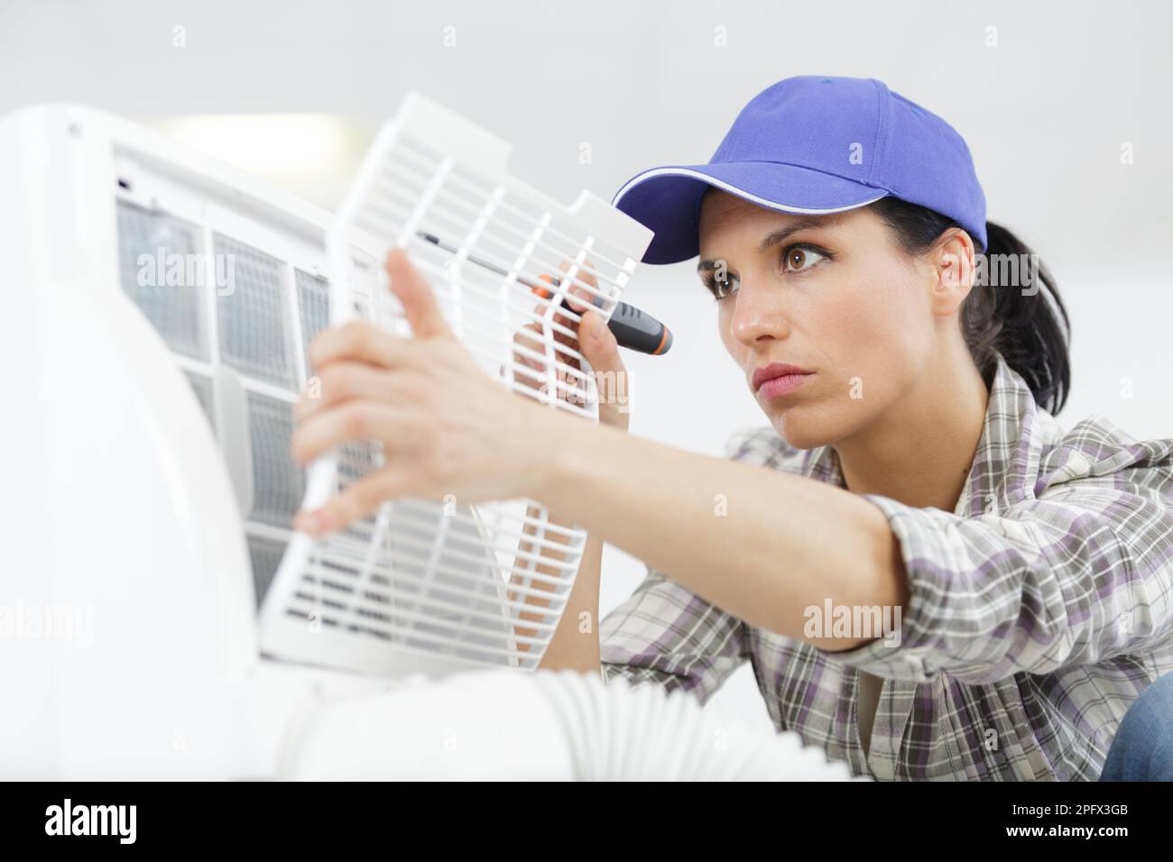 female worker repairing an air conditioner Stock Photo - Alamy