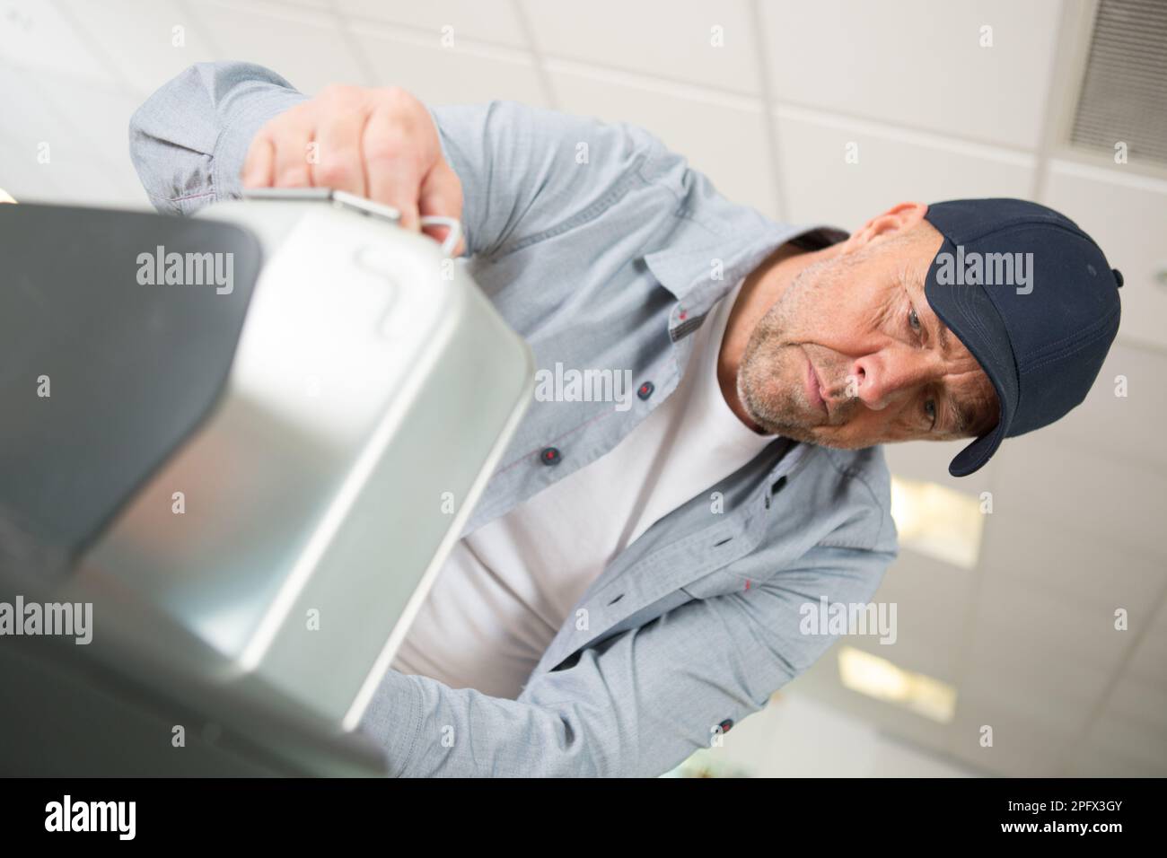 man working with an oil tank Stock Photo - Alamy