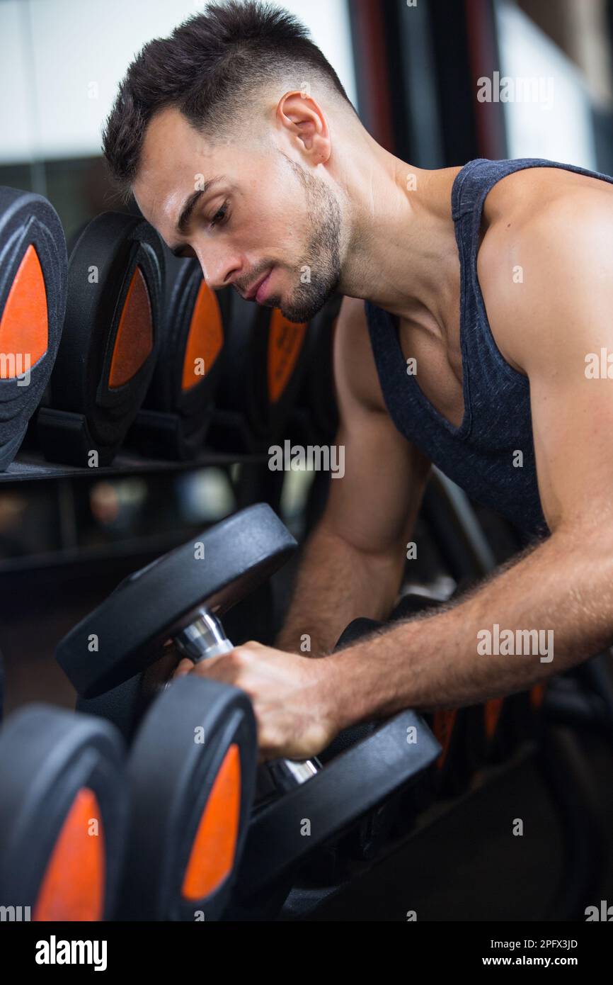 bodybuilder selecting an appropriate weight dumbbell Stock Photo - Alamy