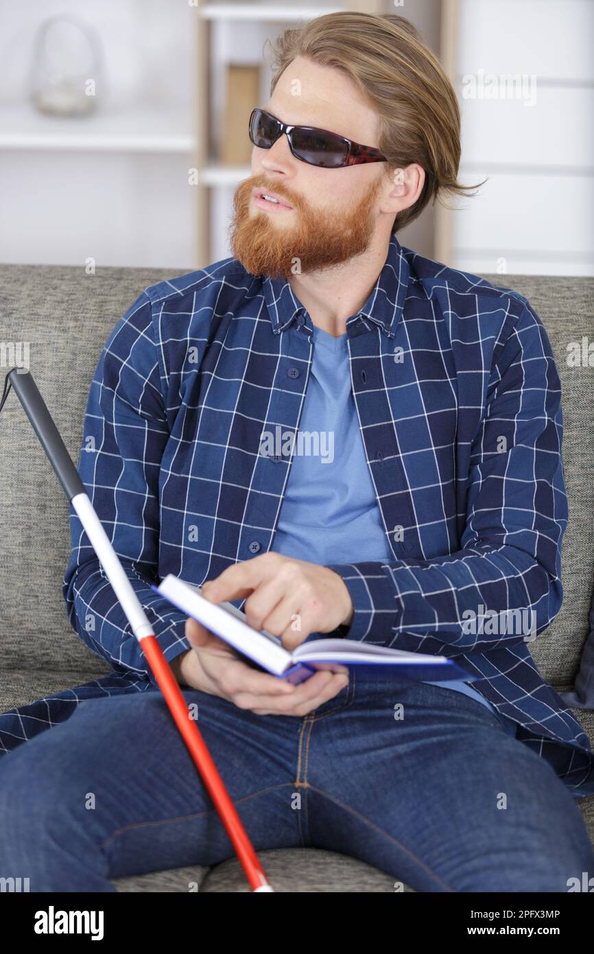 blind man reading book written in braille on sofa Stock Photo - Alamy