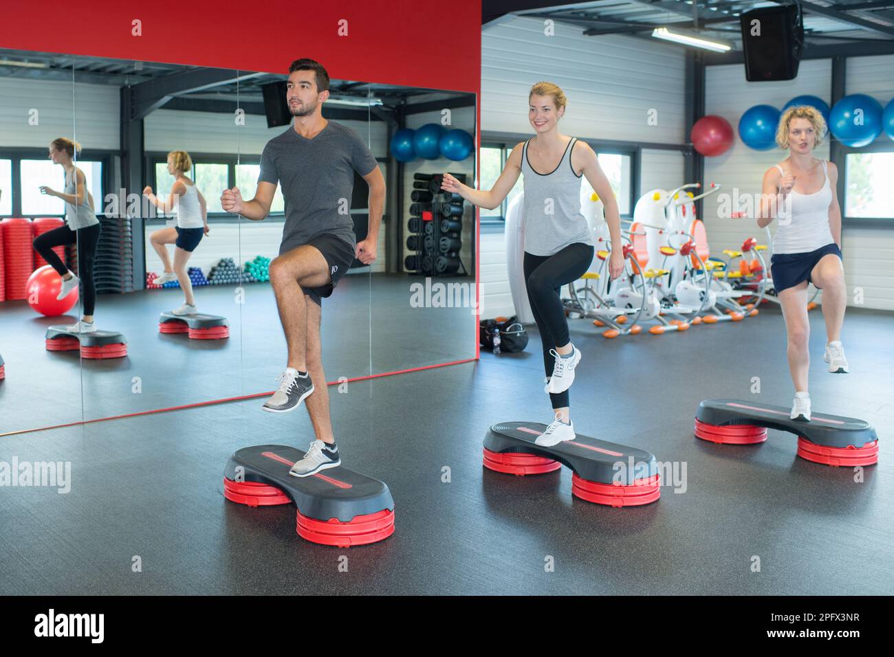 three people sychronised during step class Stock Photo - Alamy