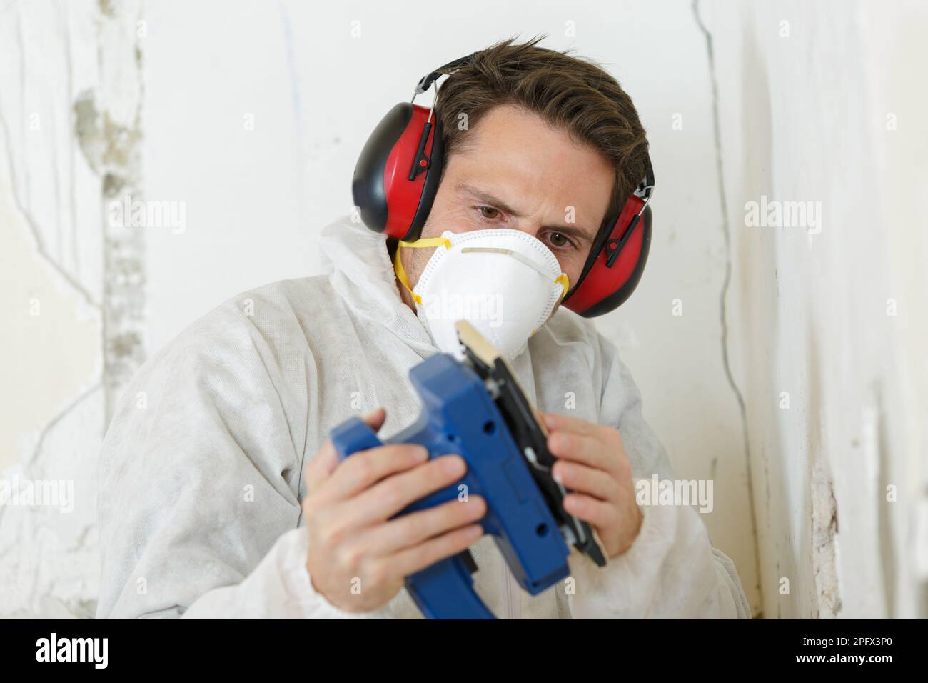 working man with sanding machine sands Stock Photo - Alamy