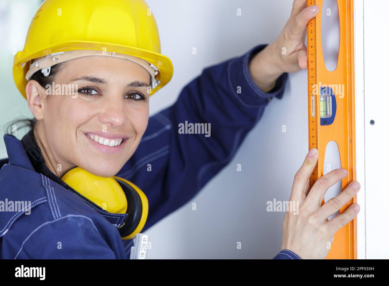 beautiful woman builder working with water level Stock Photo - Alamy