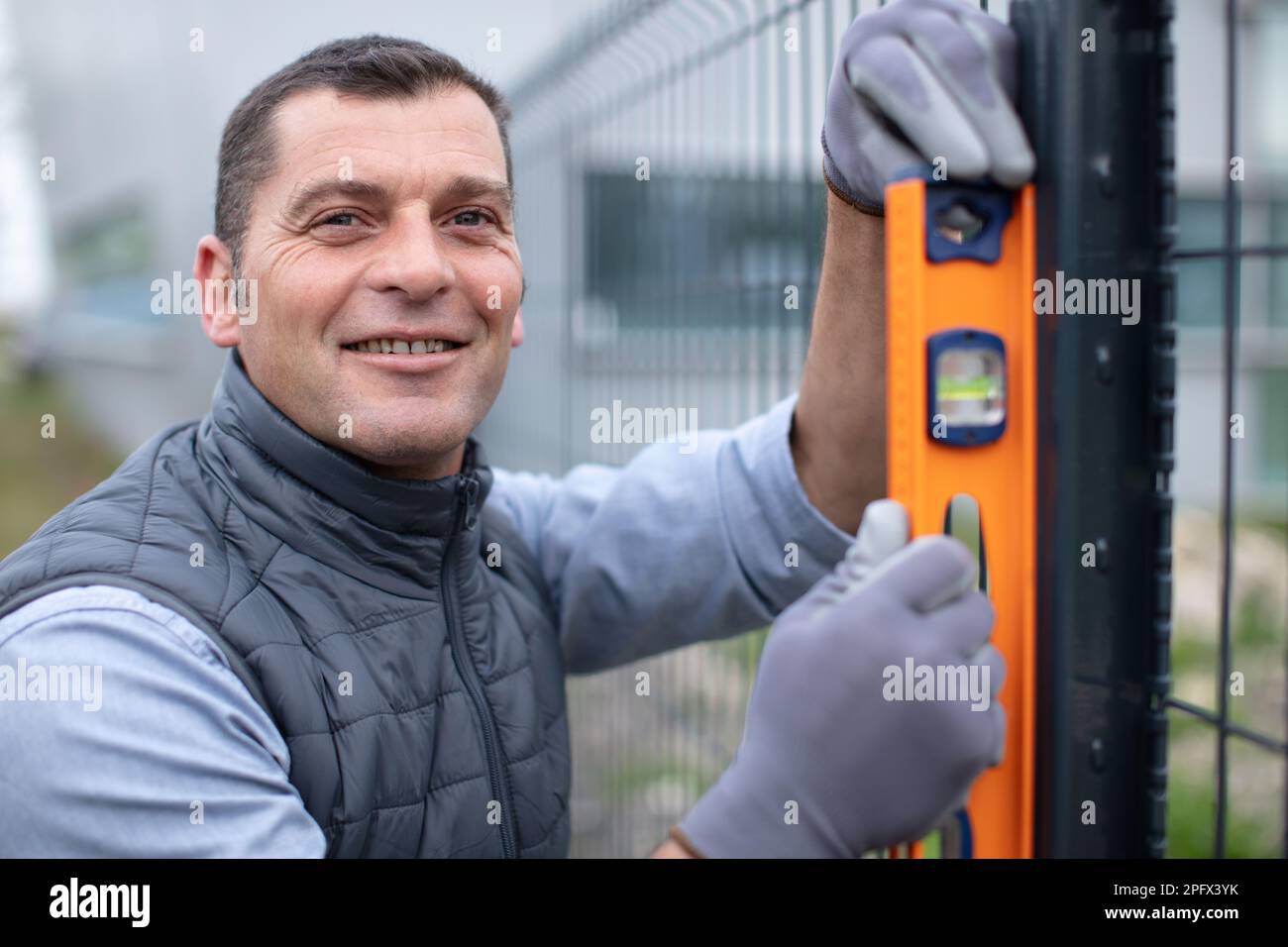 man building metal fence checking regularly with a spirit level Stock ... man building metal fence checking regularly with a spirit level Stock ...