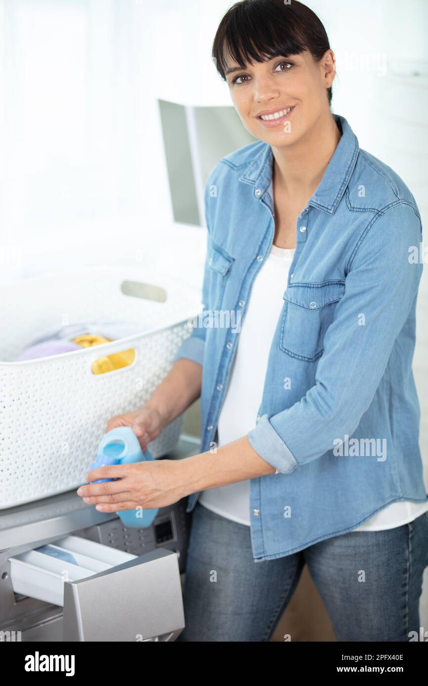 woman pouring fabric conditioner into washing machine drawer Stock ...