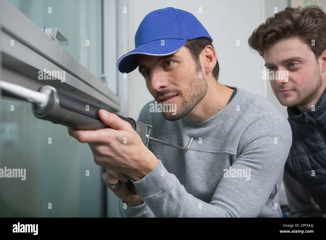 handyman using sealant gun on window Stock Photo - Alamy