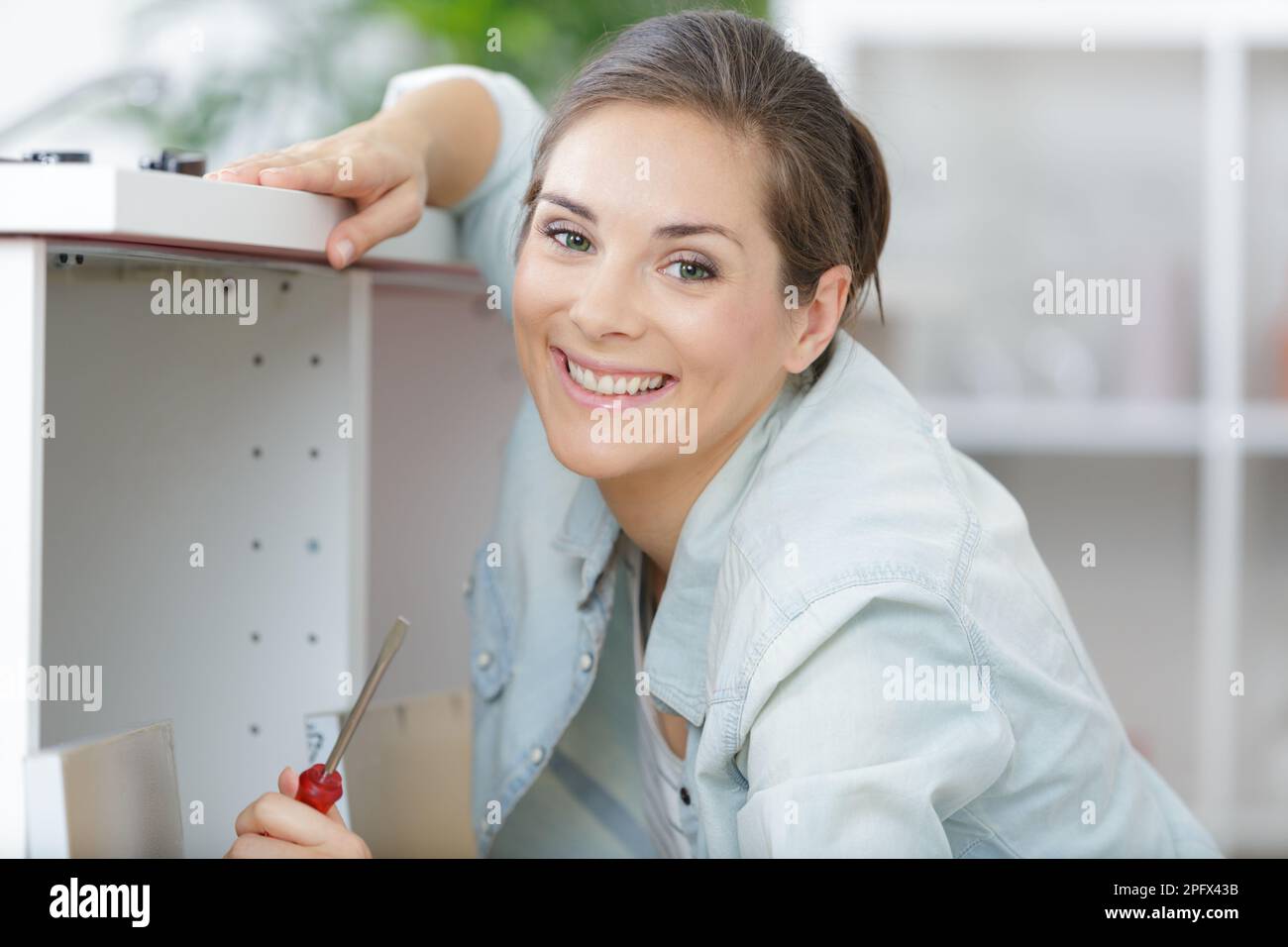 woman putting together self assembly furniture assemble flat pack Stock ...