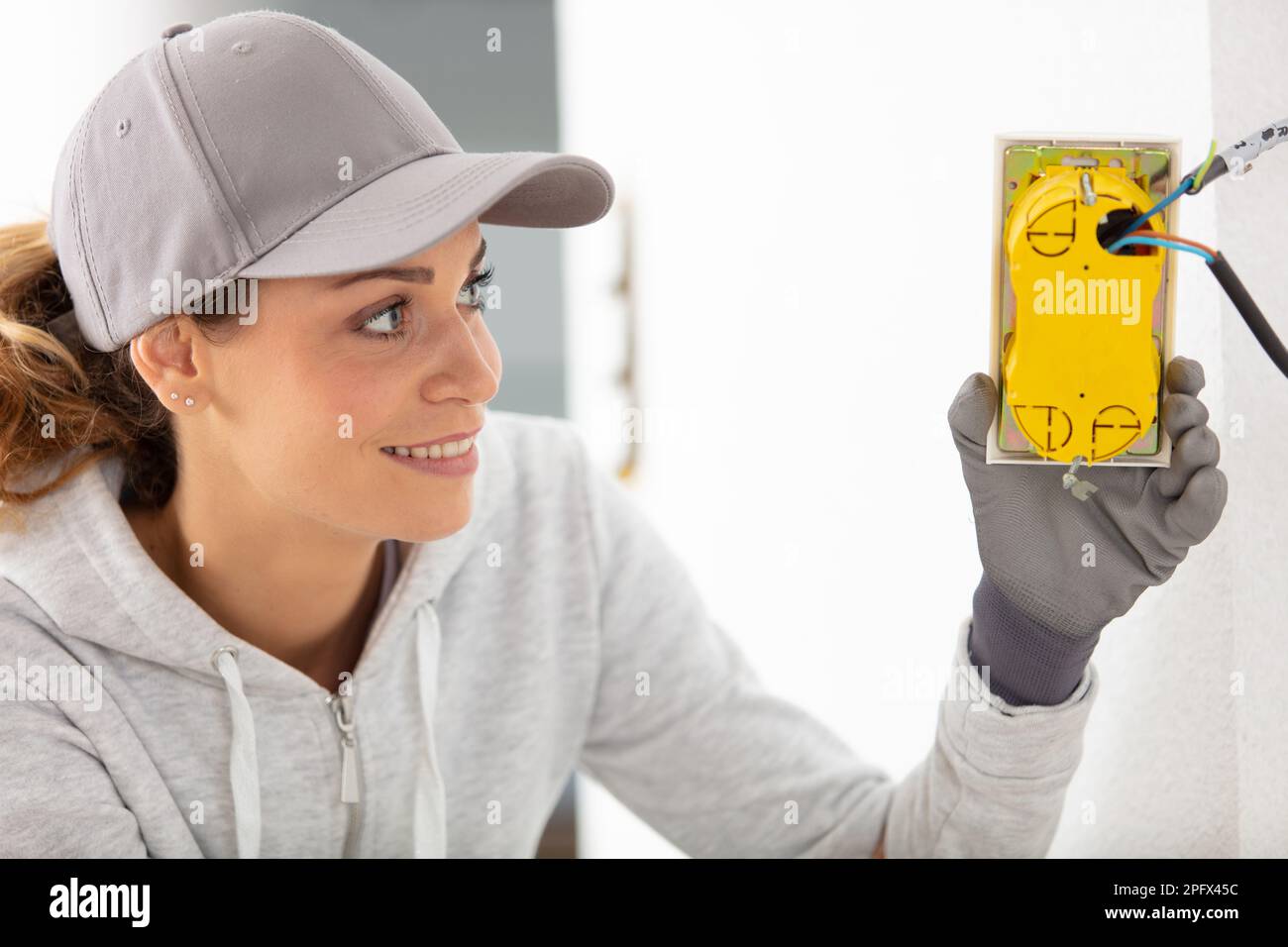 female electrician holding an electrical junction box Stock Photo - Alamy