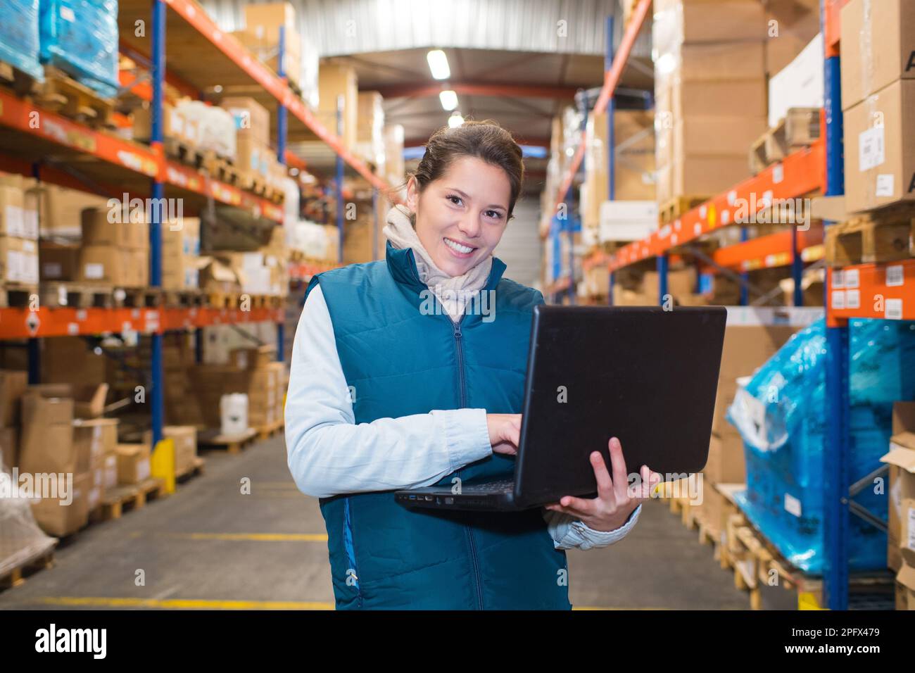 female warehouse worker using a laptop Stock Photo - Alamy