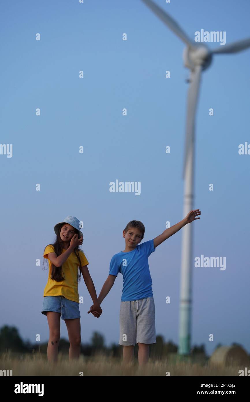 School boy stand on the wind farm. Wind turbines alternative ...