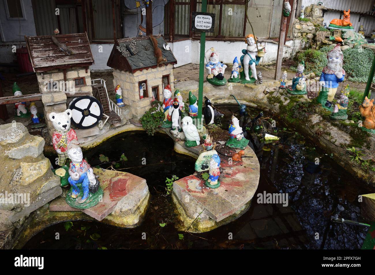 Wishing well and grotto with an assortment of garden gnomes Stock Photo ...