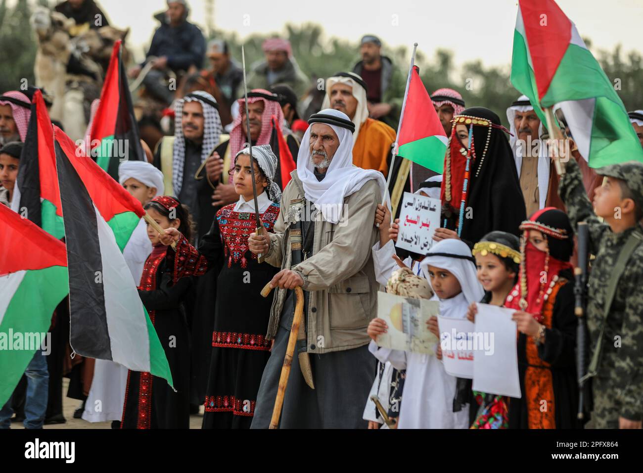 Gaza, Palestine. 18th Mar, 2023. Palestinians hold flags and placard ...