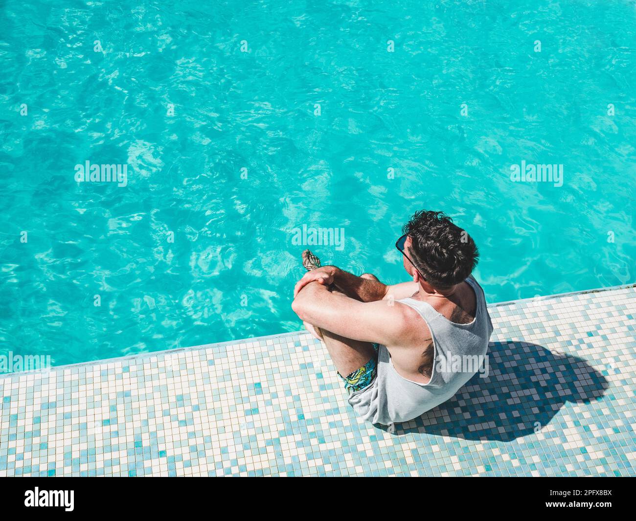 Handsome man sitting near the swimming pool Stock Photo - Alamy