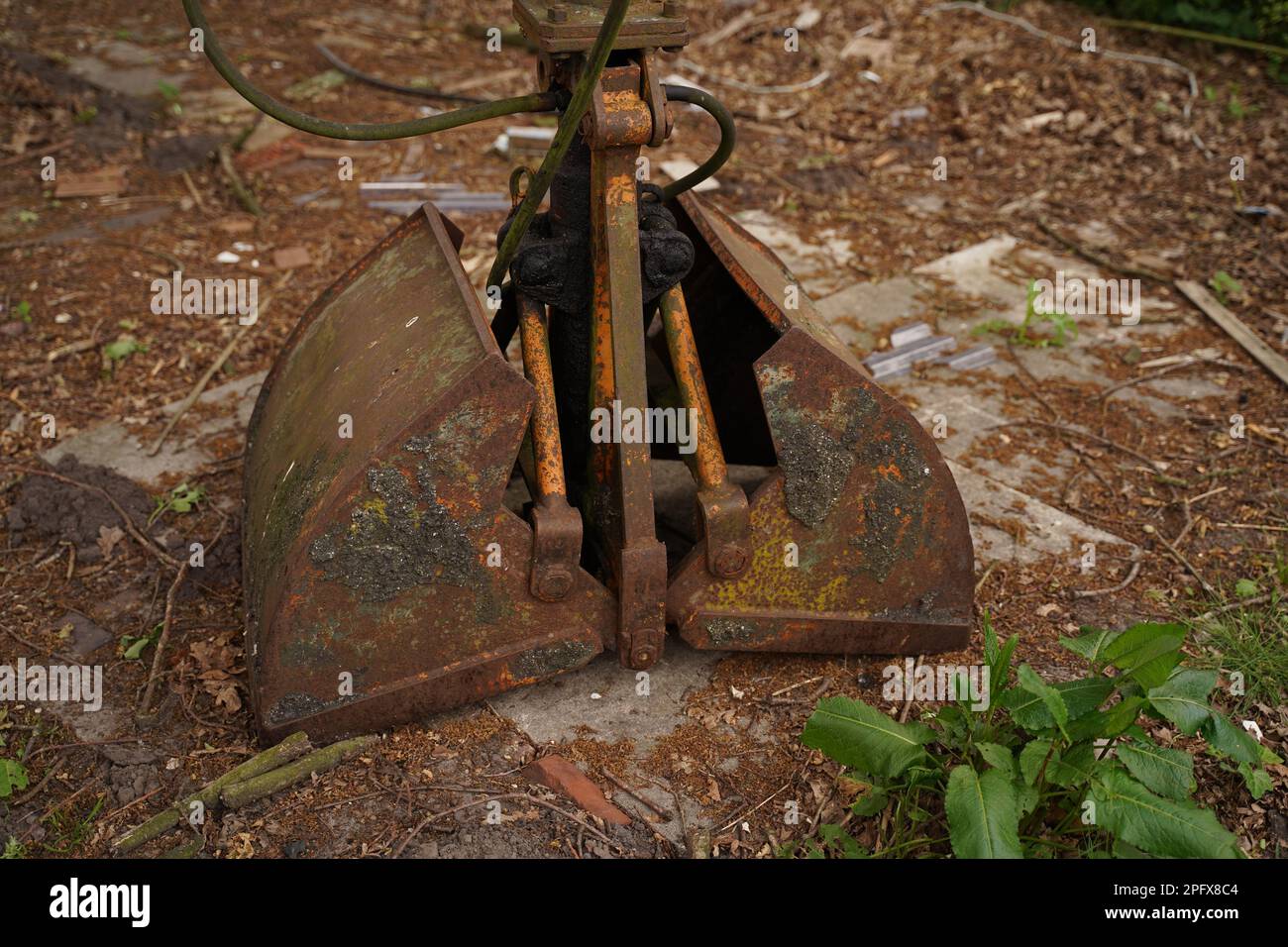 An abandoned old double bucket from a excavator at the garden. Original ...