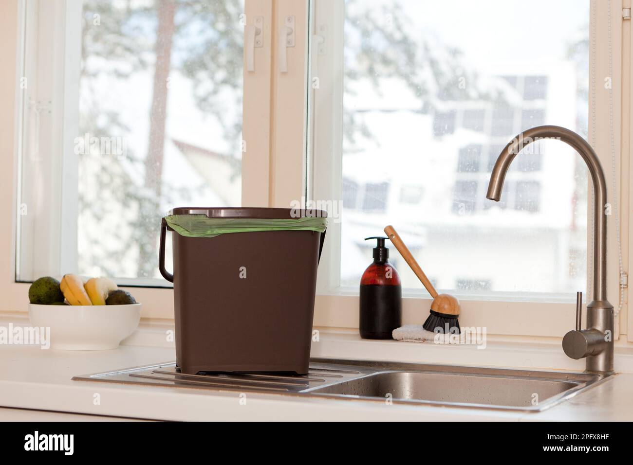 Trash bin with organic waste for composting on the kitchen near sink ...
