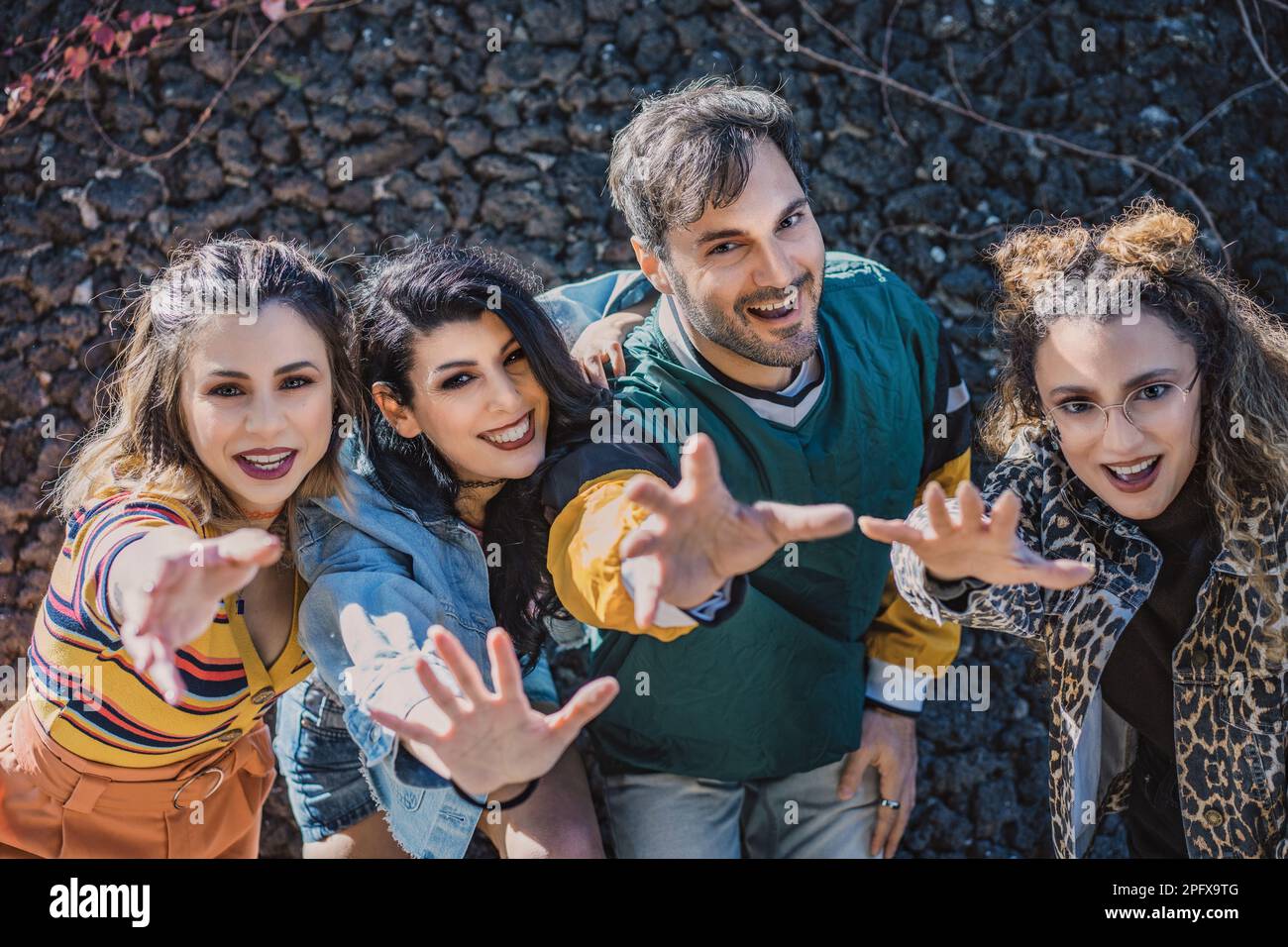 An overhead shot captures a happy group of four young adults, one man ...
