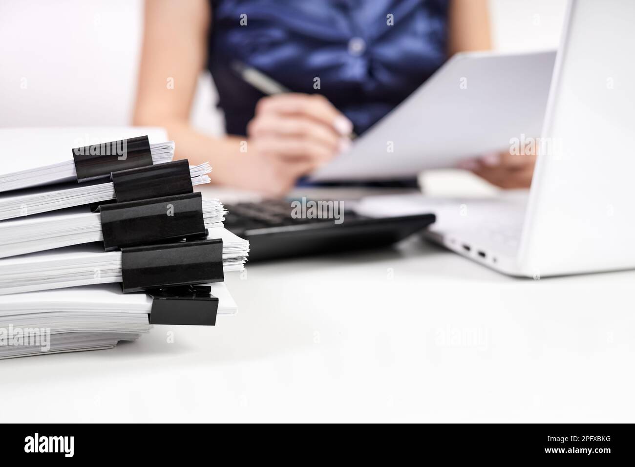 A stack of papers with Binder Clips against the background of an office ...