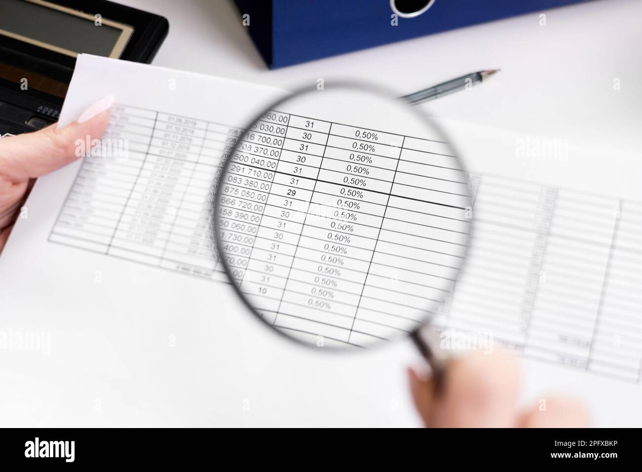 An office worker examines documents through a magnifying glass Stock ...