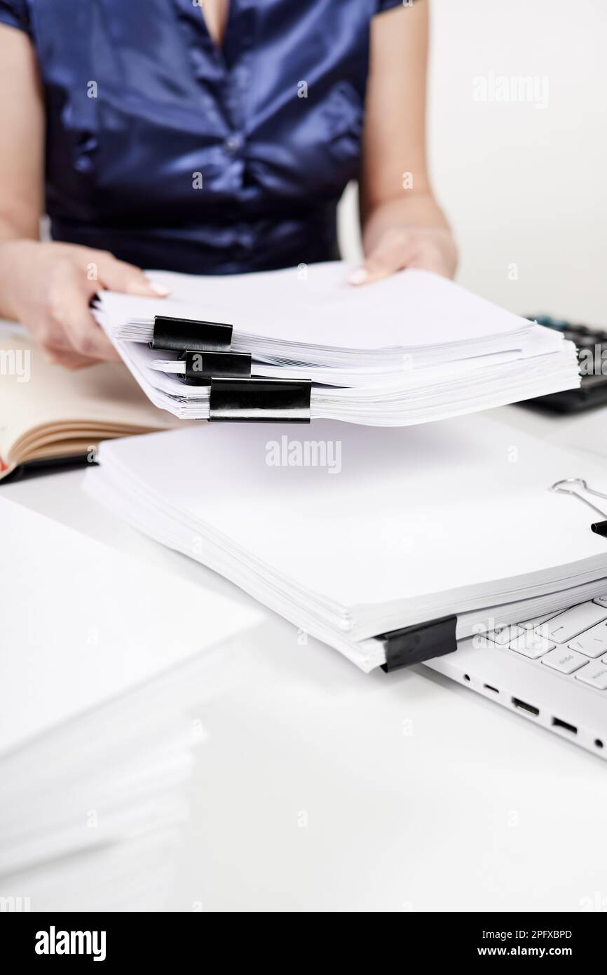 An office worker moves a stack of papers fastened with Binder Clips ...