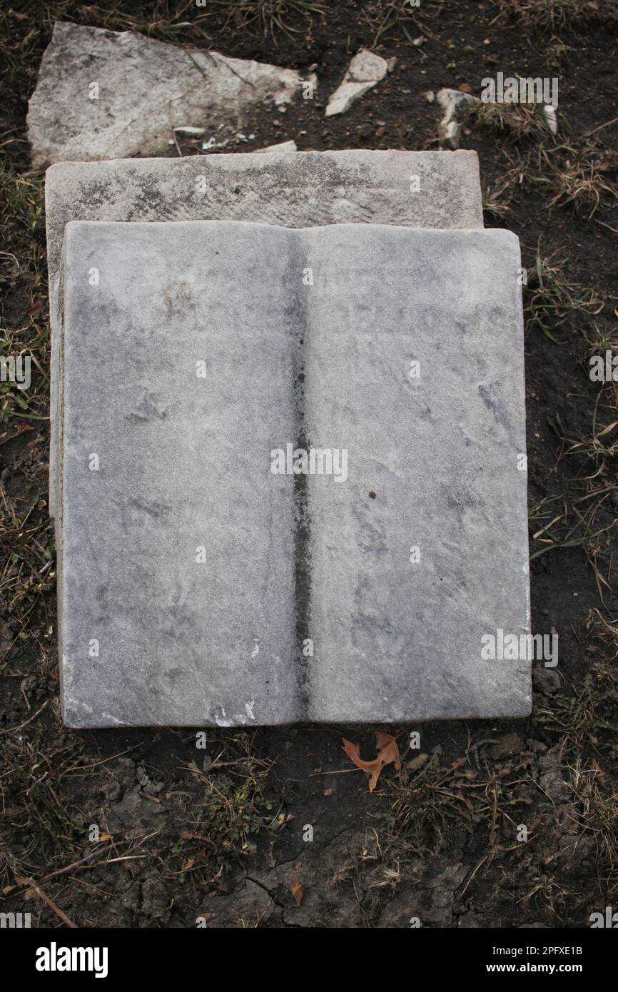 An open book carved into natural stone and a blank epitaph with room ...