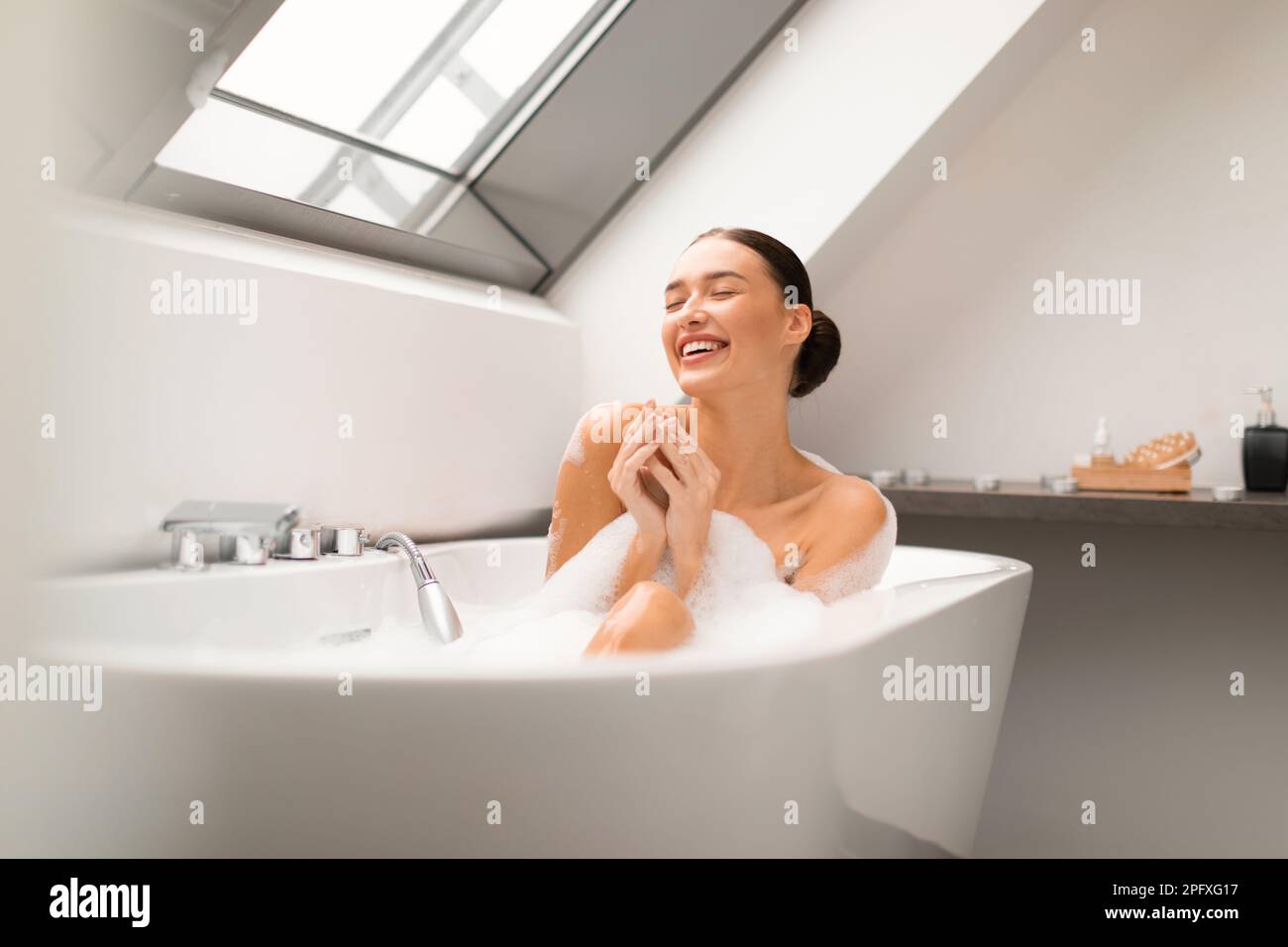 Woman Sitting In Bathtub Taking Bath With Foam In Bathroom Stock Photo ...