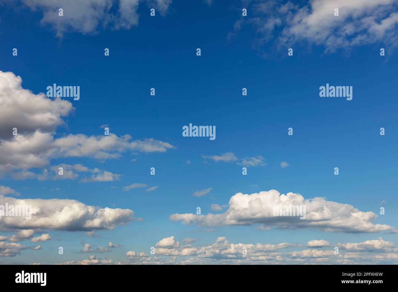 Smooth rows of white clouds on the horizon against a dense blue sky ...