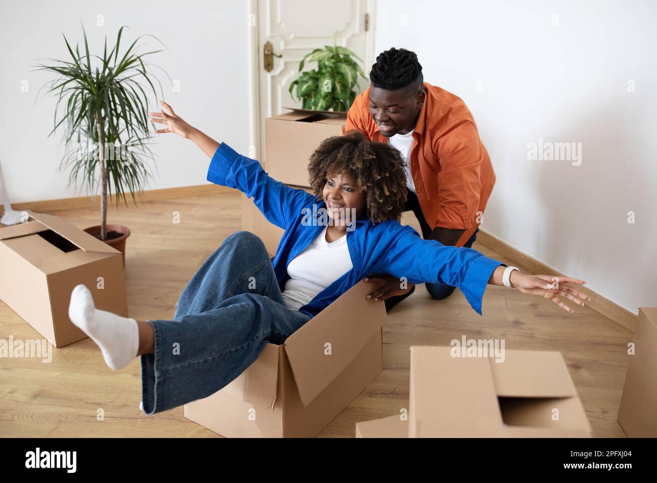 Black Couple Riding Inside Cardboard Box While Having Fun On Moving Day ...
