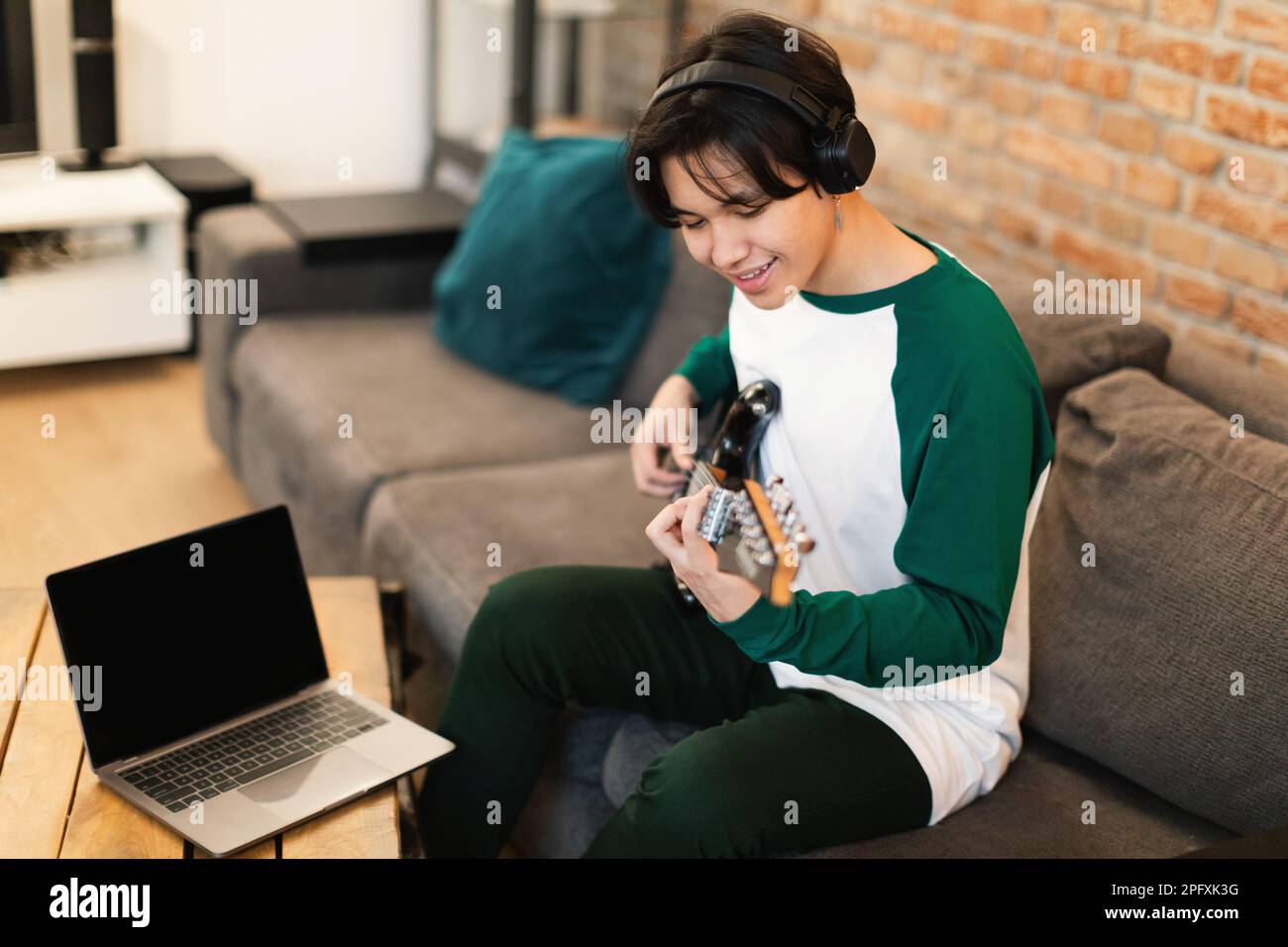 Japanese Boy Playing Chords On Electric Guitar Near Laptop Indoor Stock ...