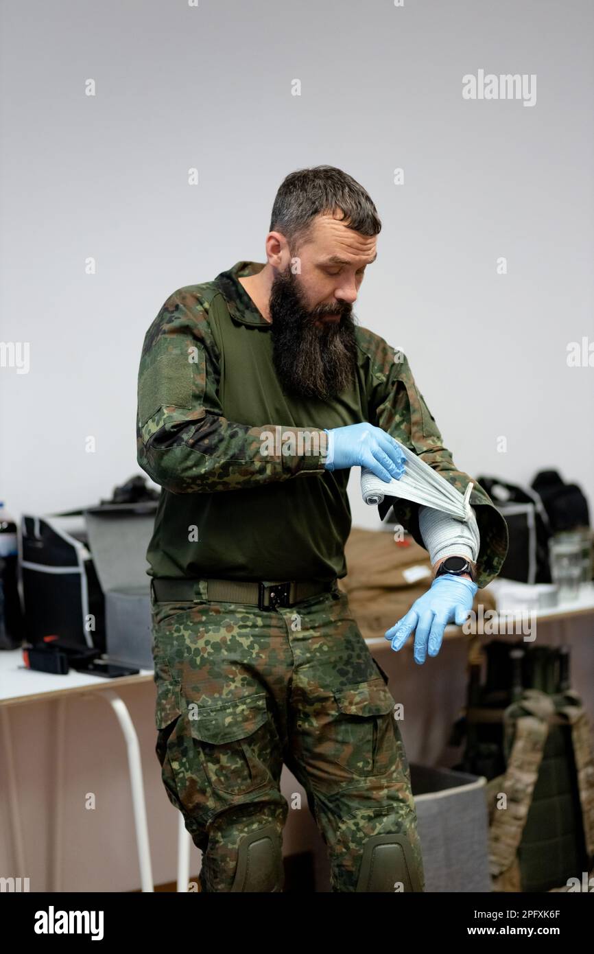 A 40-year-old bearded doctor demonstrates dressing an injured hand with ...