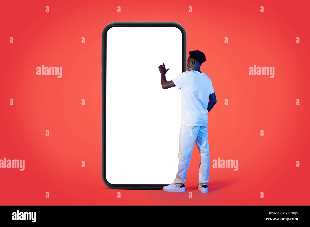 Black man touching empty white screen of huge smartphone Stock Photo ...