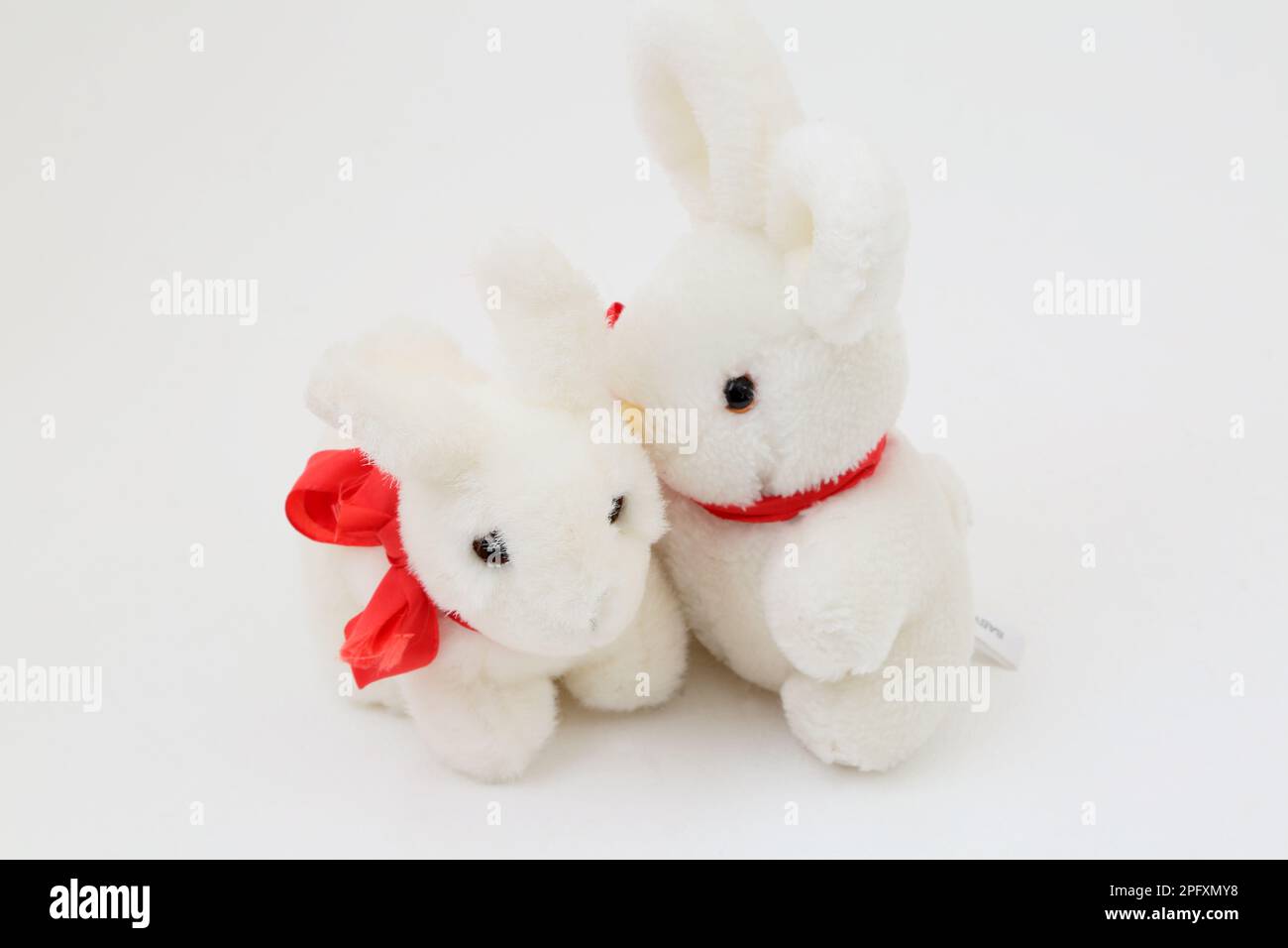Two White Soft Rabbits with Red Bows Stock Photo - Alamy